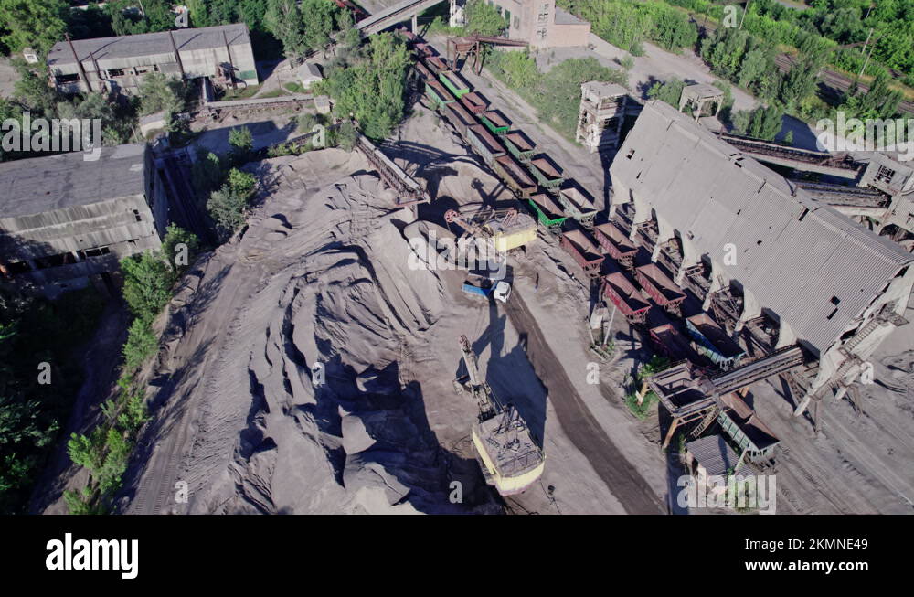 Excavator loading crushed stone into a dump truck in a crushed stone ...