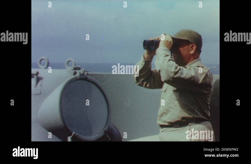 1940s: Flags on navy ship. Officer looks through binoculars. Officer ...