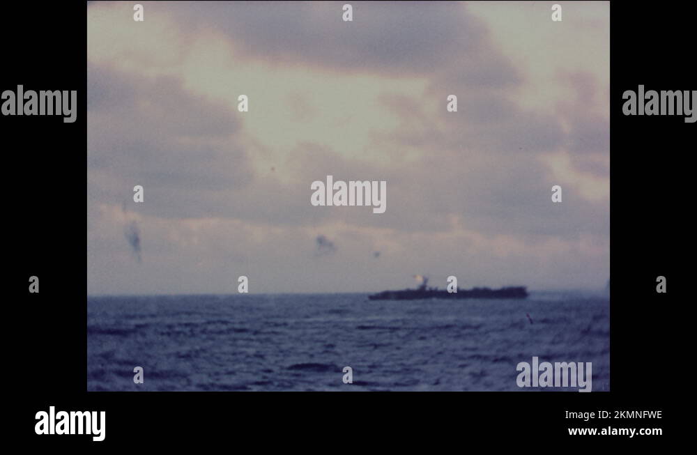 1940s: Cannons fire on navy ship at sea. Explosion in ocean. Sailor ...