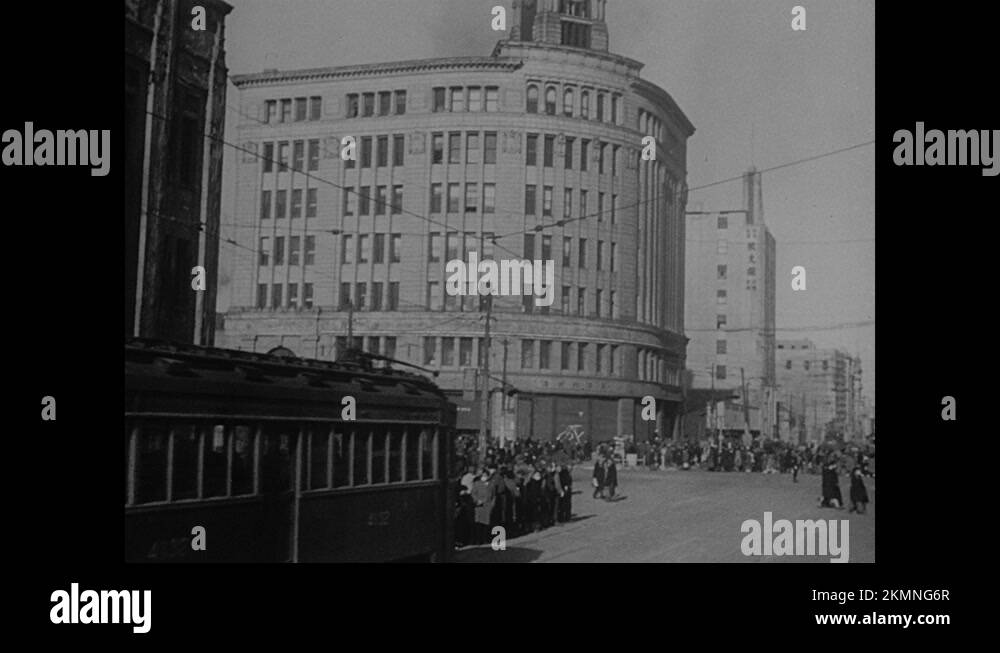 1940s: City. Newspaper headline reads "ATOM BOMB STUNS FOE." Text. Map ...