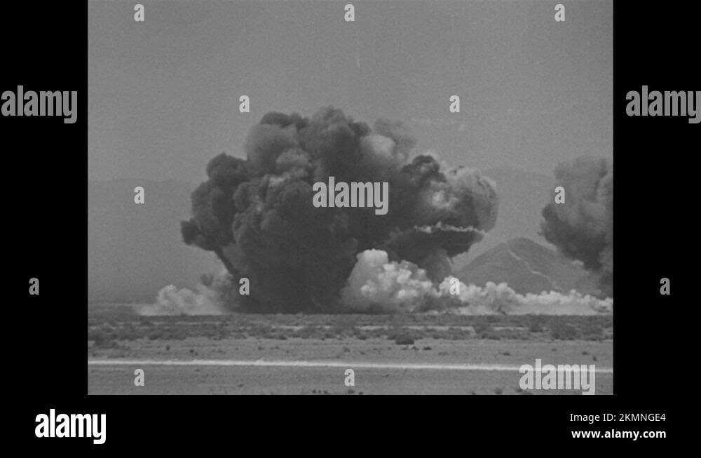 1940s: Fighter jet in flight fires missiles. Missiles explode on ground ...