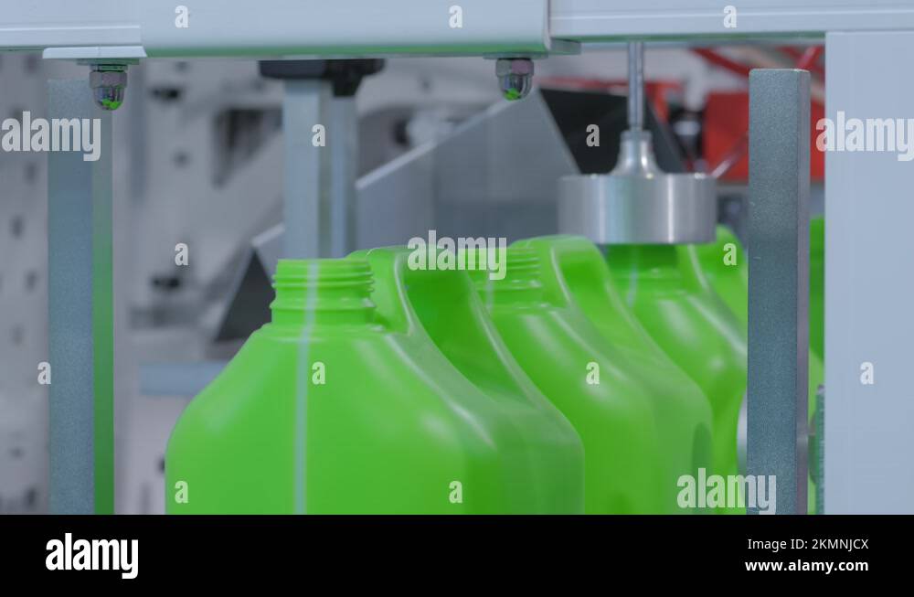 Close up: empty green plastic jerry cans falling from conveyor belt at ...