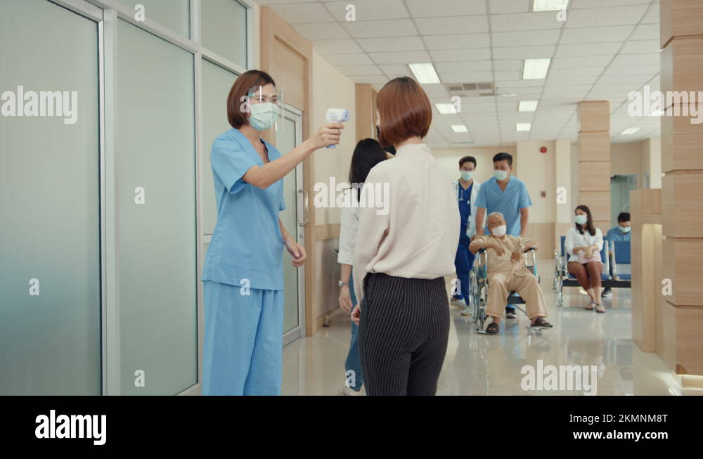 Asian doctor walk through hospital with helper staff push patient ...