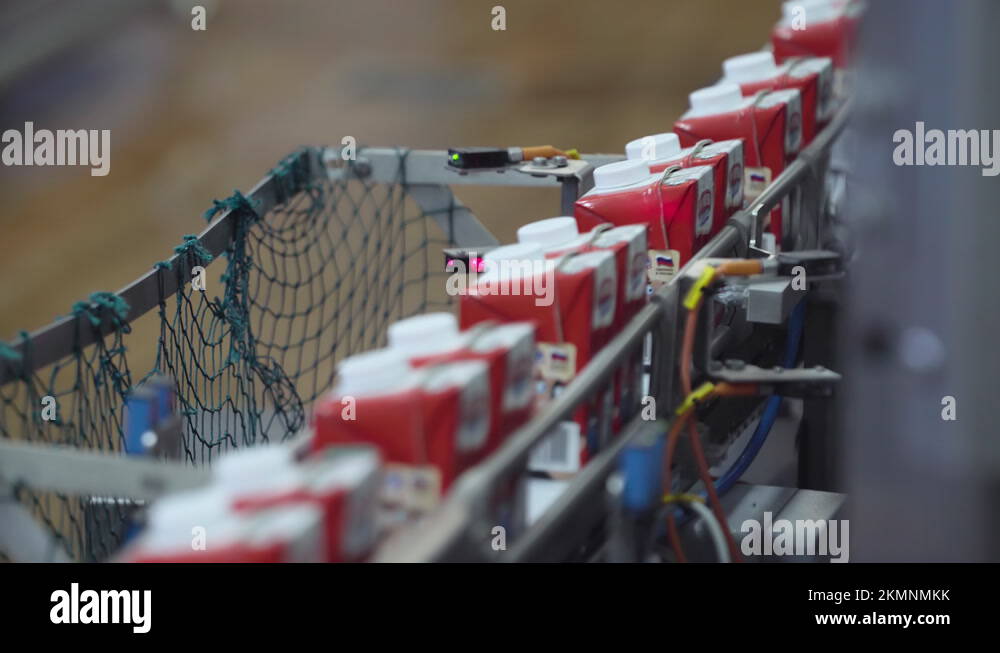 Small Red Milk Packages are exiting the automatic conveyor line at ...