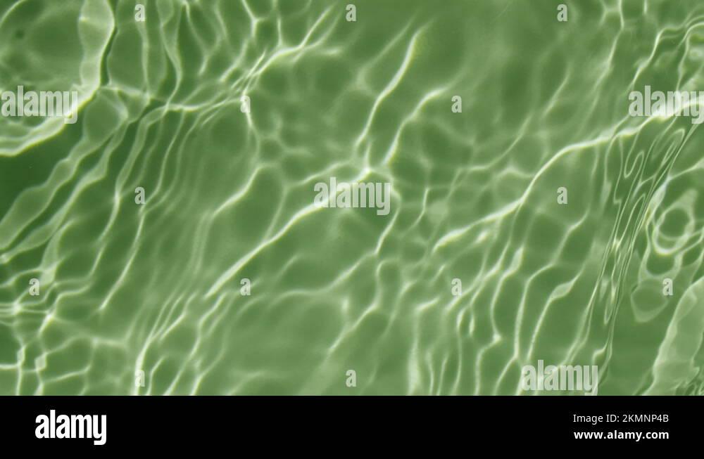 Water splash green colored. Drop falls into water and diverging circles ...