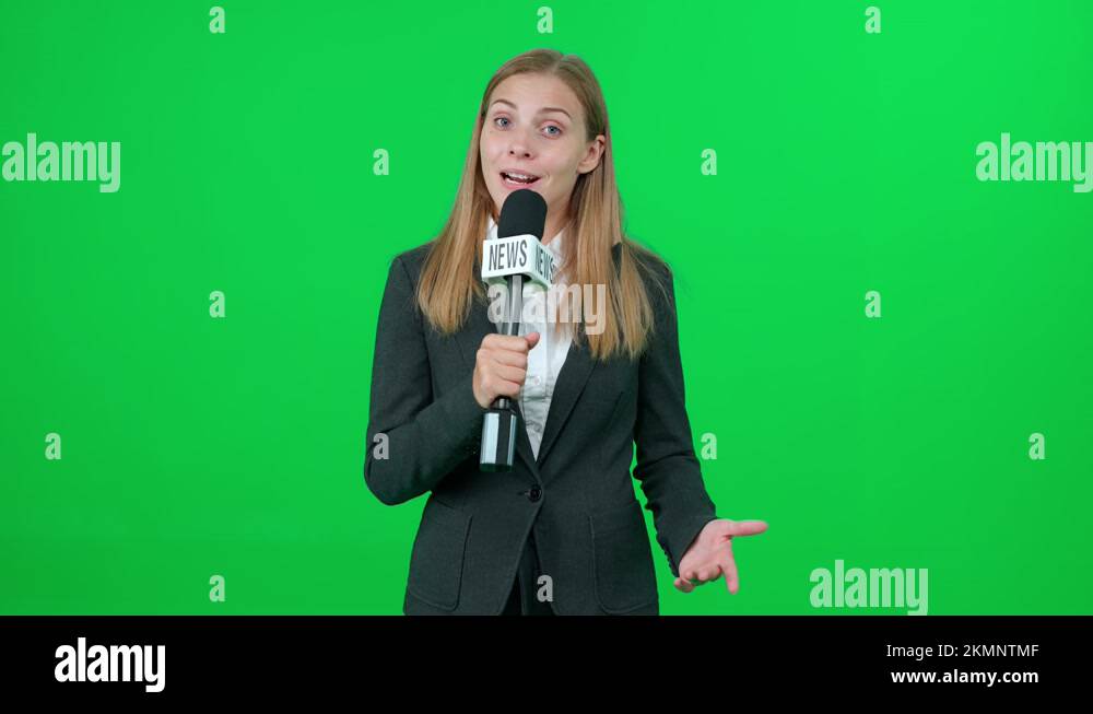 Female news reporter speaks into a microphone on a green background and ...