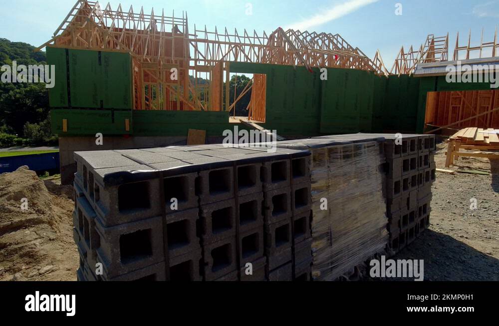 Pan from cubes of construction block to new home under construction ...