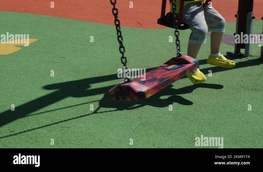 Swing and child, full and empty swing in the playground, sunlight and ...