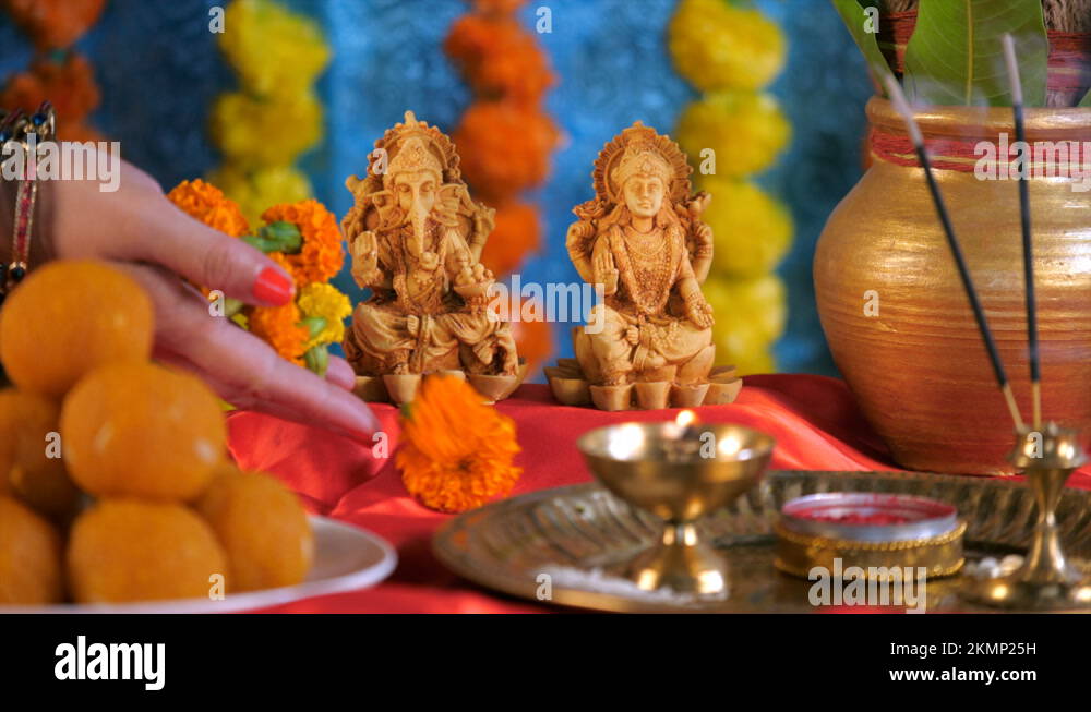 Lady offering marigold flowers to Lord Ganesha and Devi Laxshmi on ...