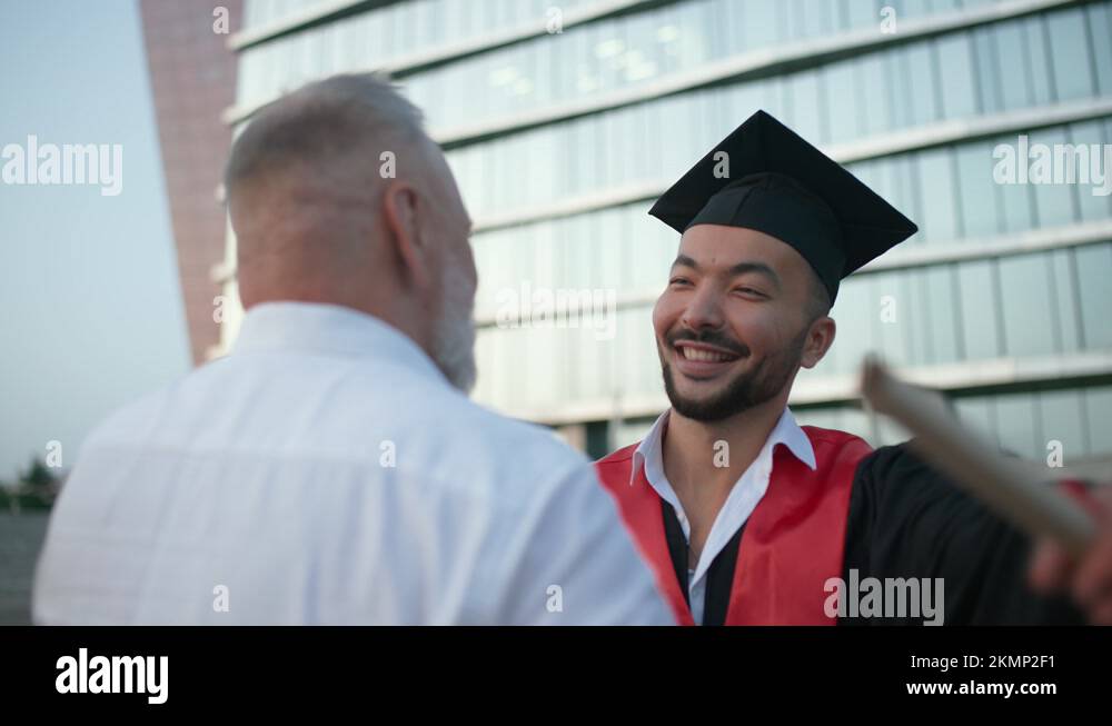 Graduation, a father embraces his son, a university graduate, young man ...