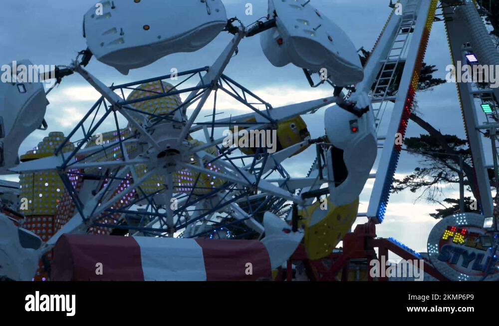 Carnival Rides spinning and rotating with flashing neon lights dusk ...