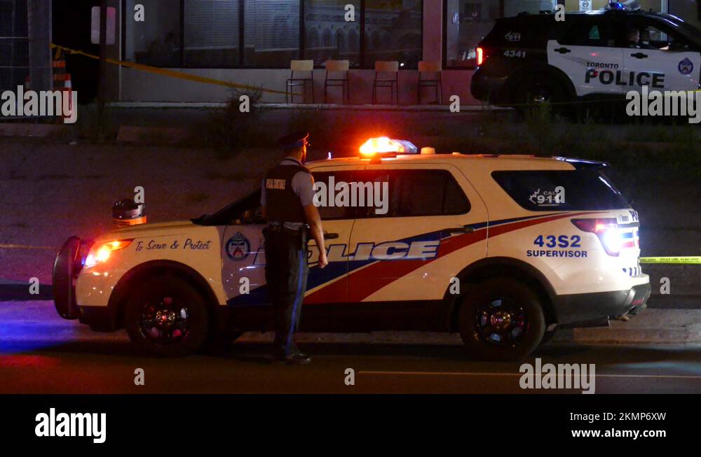 Police Standing And Talking Outside Police Car With Flashing Sirens ...