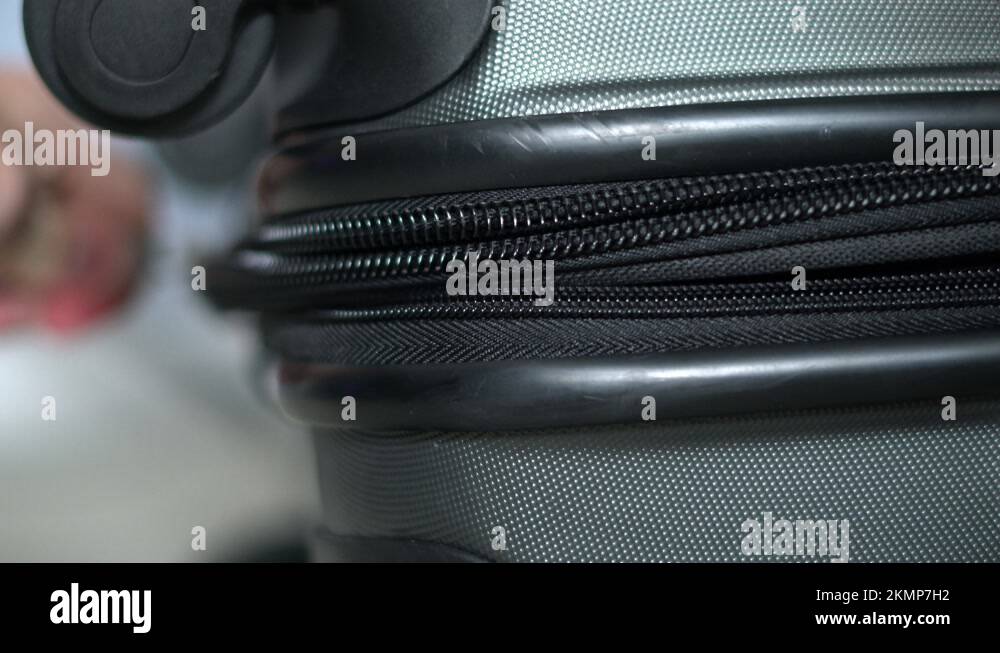 Closing carry on luggage suitcase with wheels to take to airport and ...