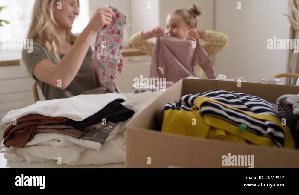 Video of mother and daughter sorting clothes for donation Stock Video ...