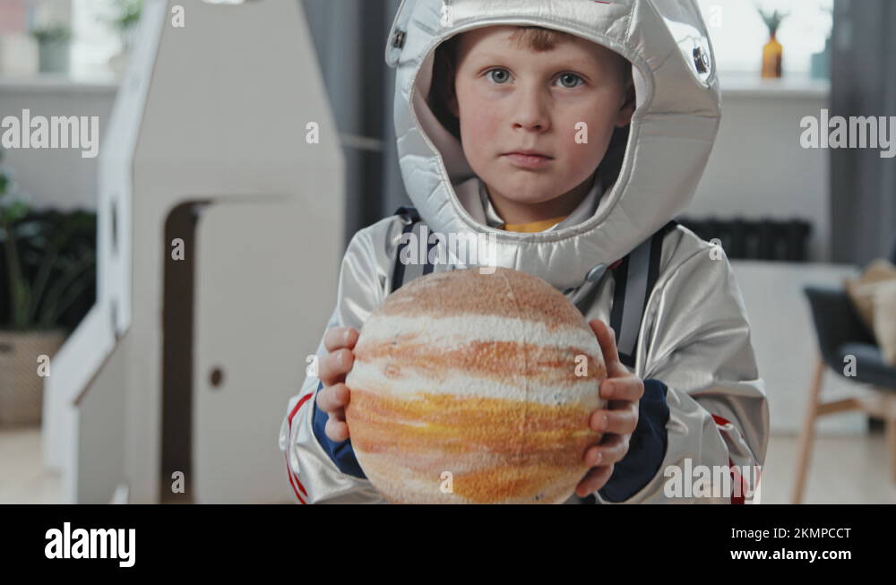 Cute Boy in Spacesuit Holding Model of Planet Stock Video Footage - Alamy