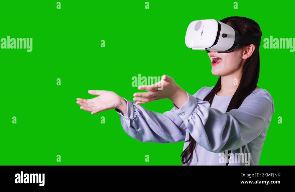 Young asian woman wearing VR goggles. Green background for chroma key ...