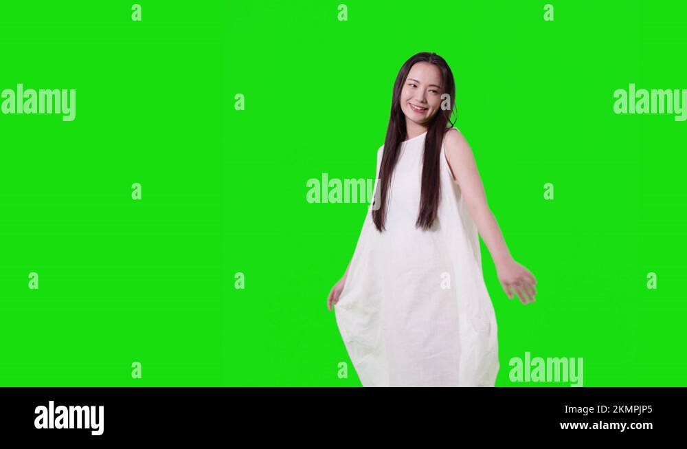 Young asian woman wearing white dress. Green background for chroma key ...