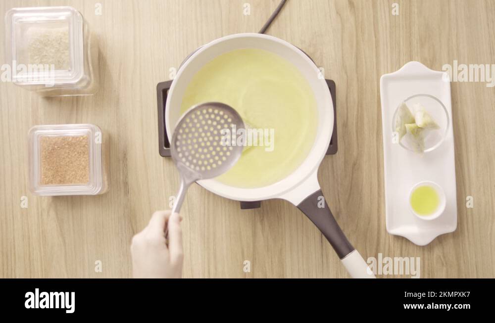 Cook putting food in boiling oil in a white pot, top view static Stock ...
