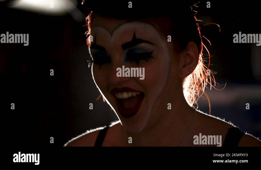 Horror scene - clown woman laughing in sadistic joy in a dark and scary ...