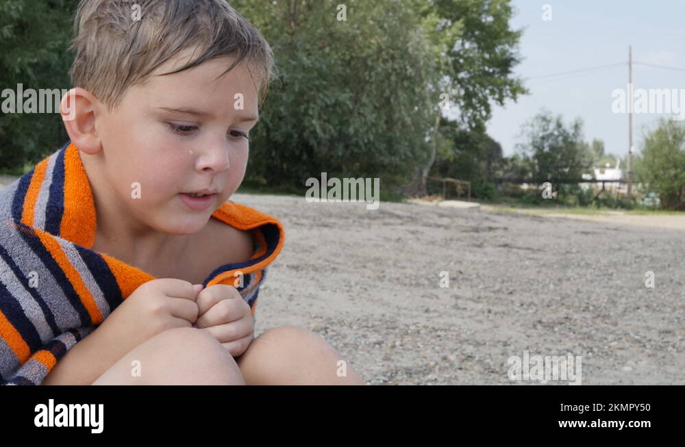 teen boy shivering from the cold wrapped in a towel from bathing too ...