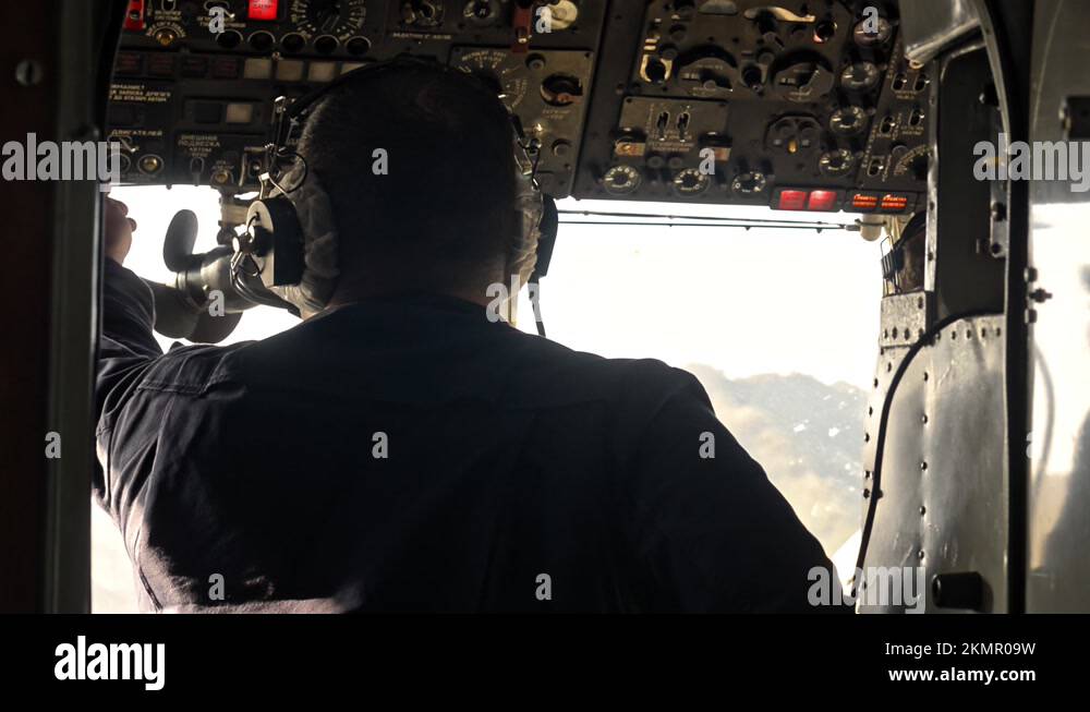 Back view of male pilot aviating helicopter and sitting in cockpit ...