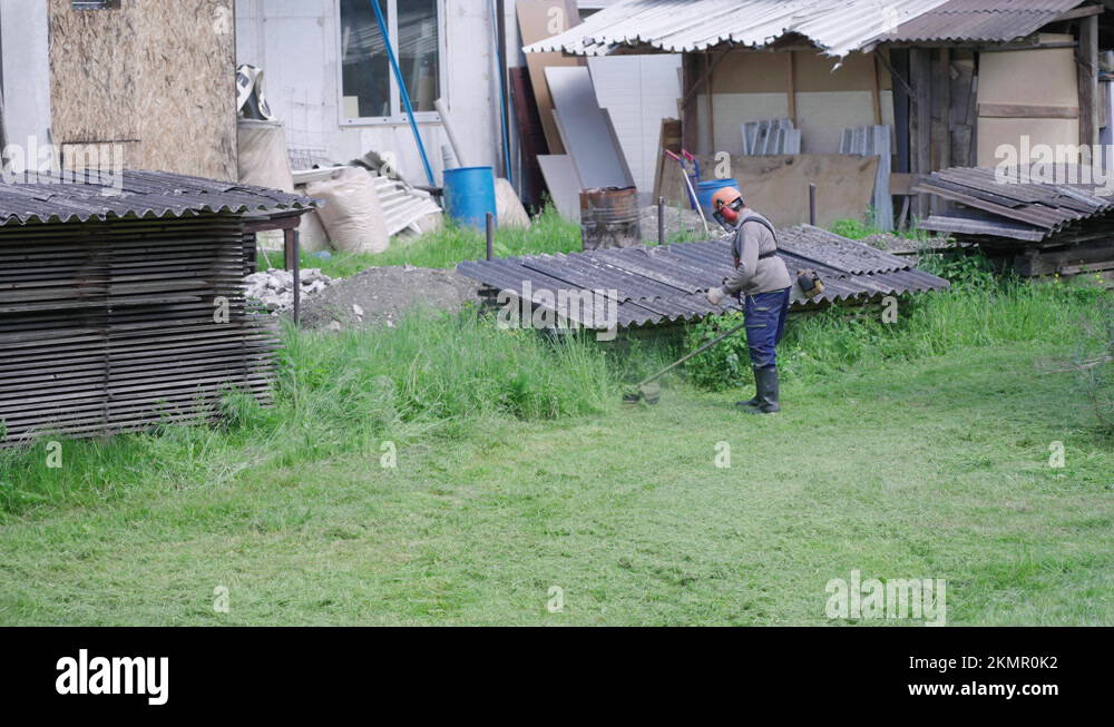 Farmer in protected suit and mask mowing grass in slow motion 4K Stock ...