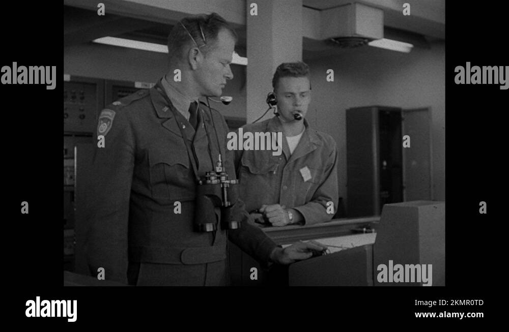 1950s: Soldiers standing at table. Soldiers wearing headsets. Hand on ...