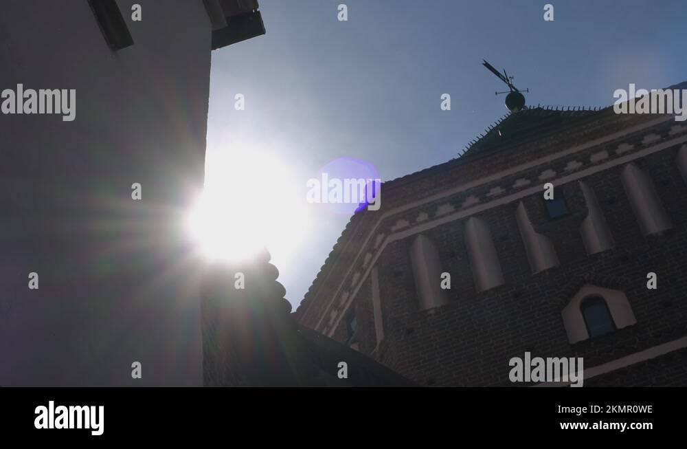 Sunbeam appears from white wall of old medieval castle. Insects, birds ...