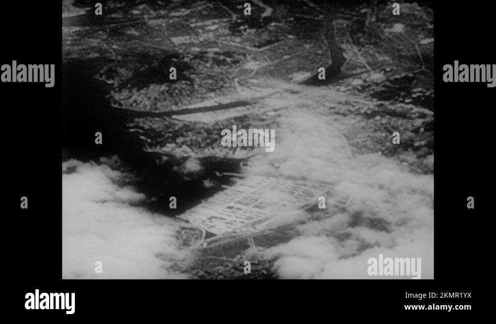 1940s: Fighter plane in sky. Flying, looking down on land. Nuclear bomb ...