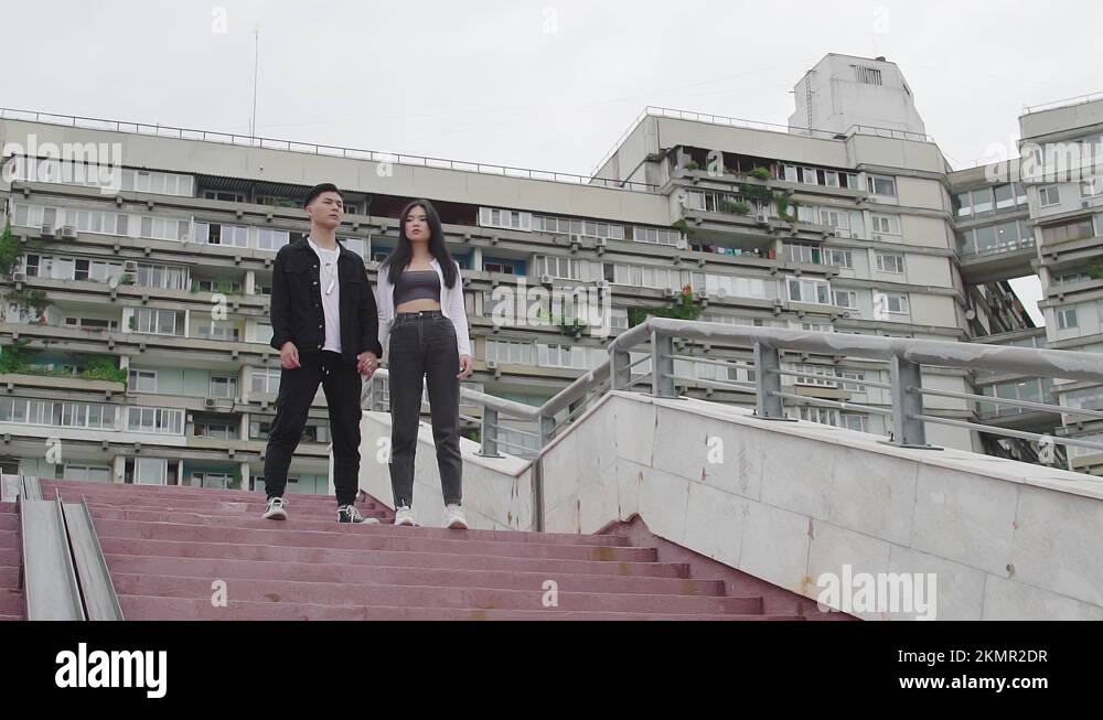 Cool and moody asian couple staing on red stair in the city in cloudy day Stock Video Footage ...
