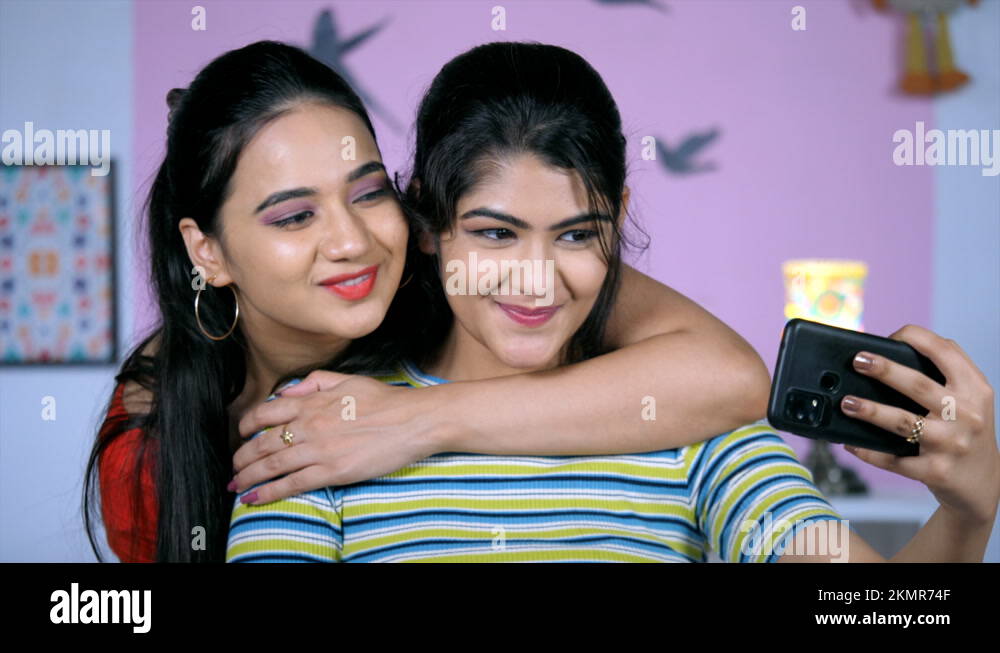 Beautiful teenage girls clicking a selfie with a thumbs-up and a ...