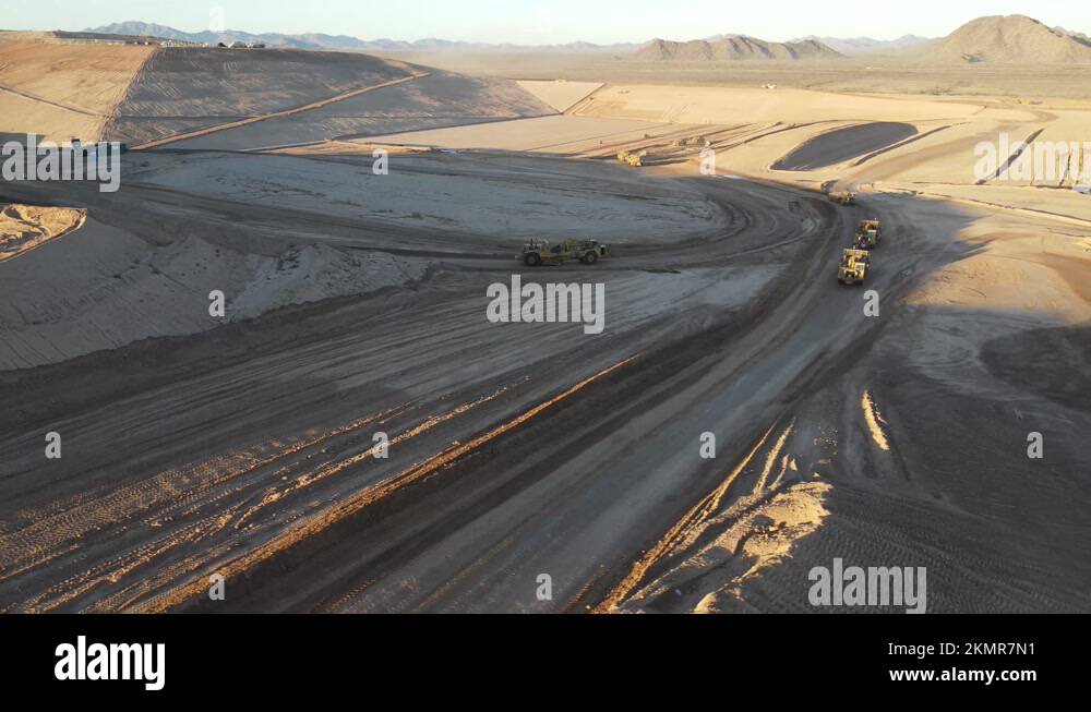 Belly Scraper tractor in large dirt patch pushing downhill. 4k drone ...