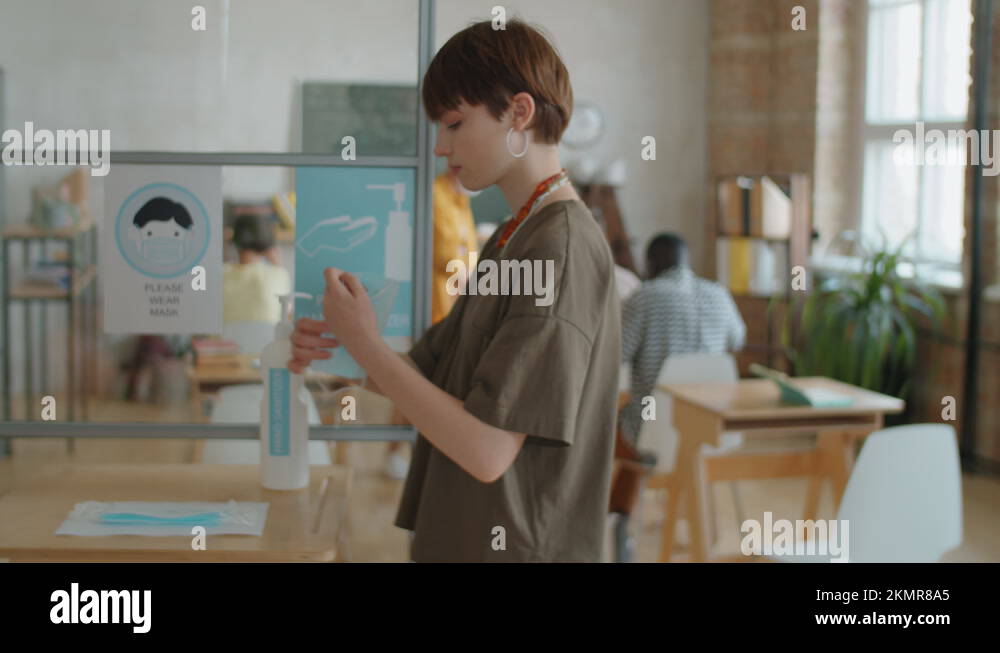 Students Putting on Masks and Applying Hand Sanitizer before Lesson ...