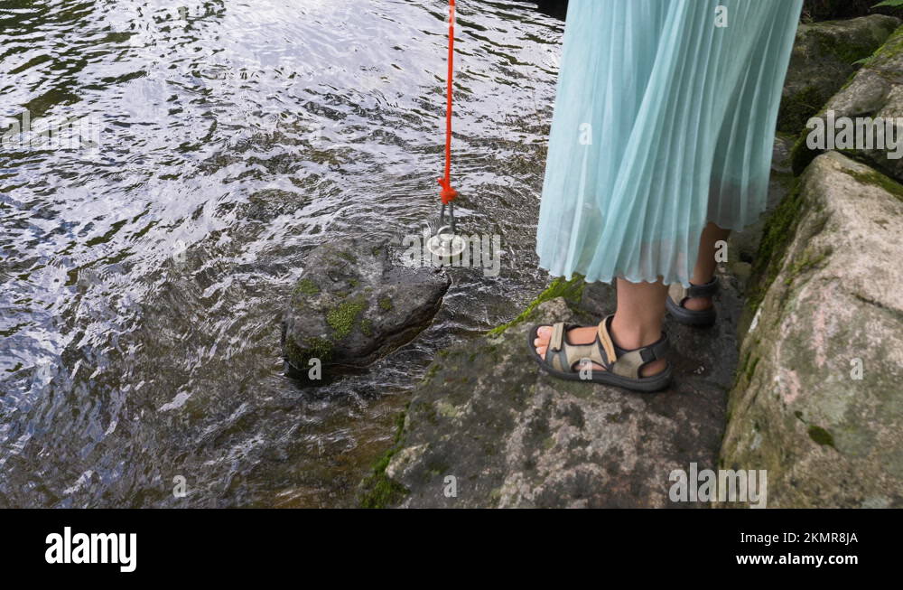 A lady pull up the rope to check her find and drop the neodymium magnet ...