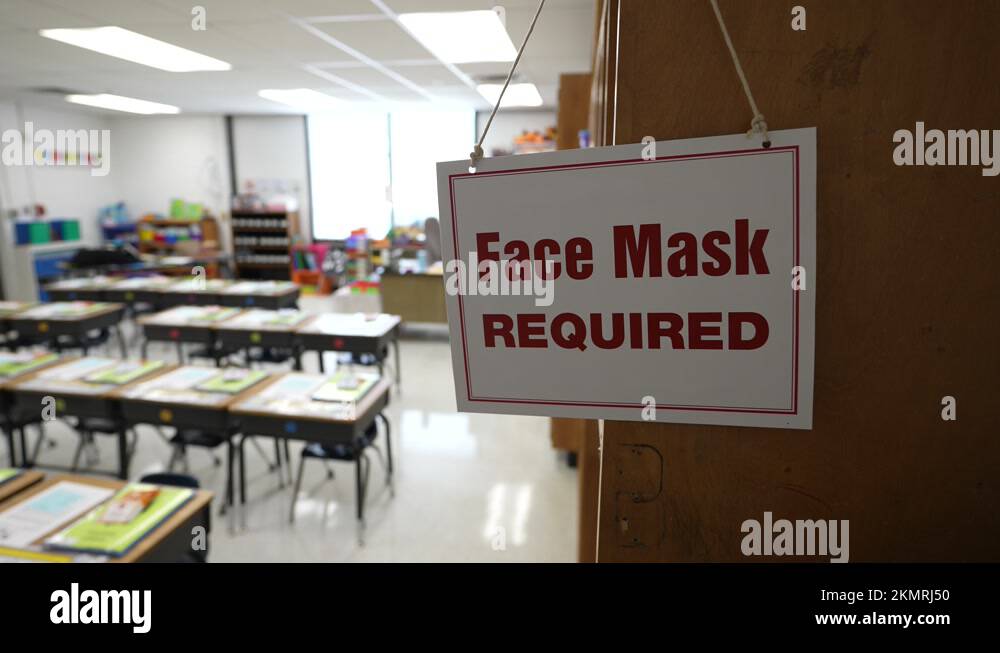 Push in on Face Mask Required sign in empty school classroom during ...