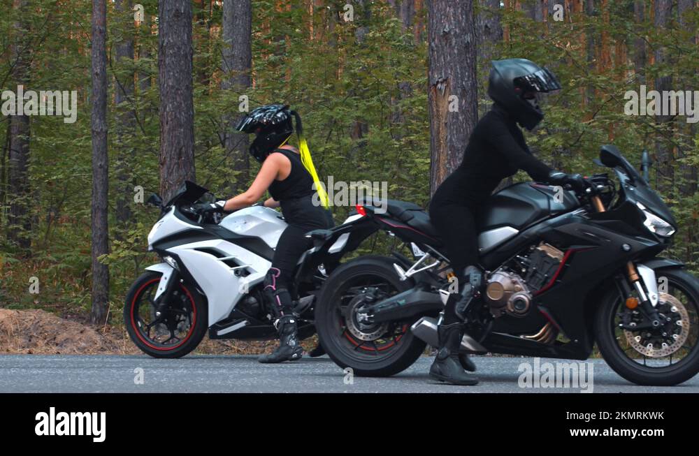 Motor riding - two women in helmets diverge to different parts of the ...