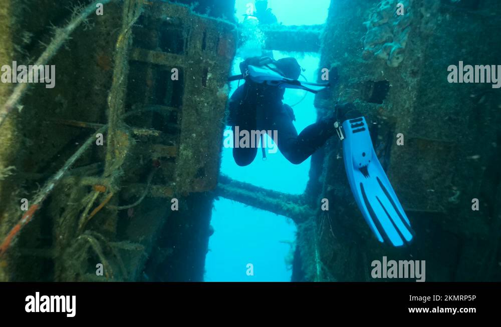 Scuba diver photographer swims on the shipwreck Swedish ferry MS ...