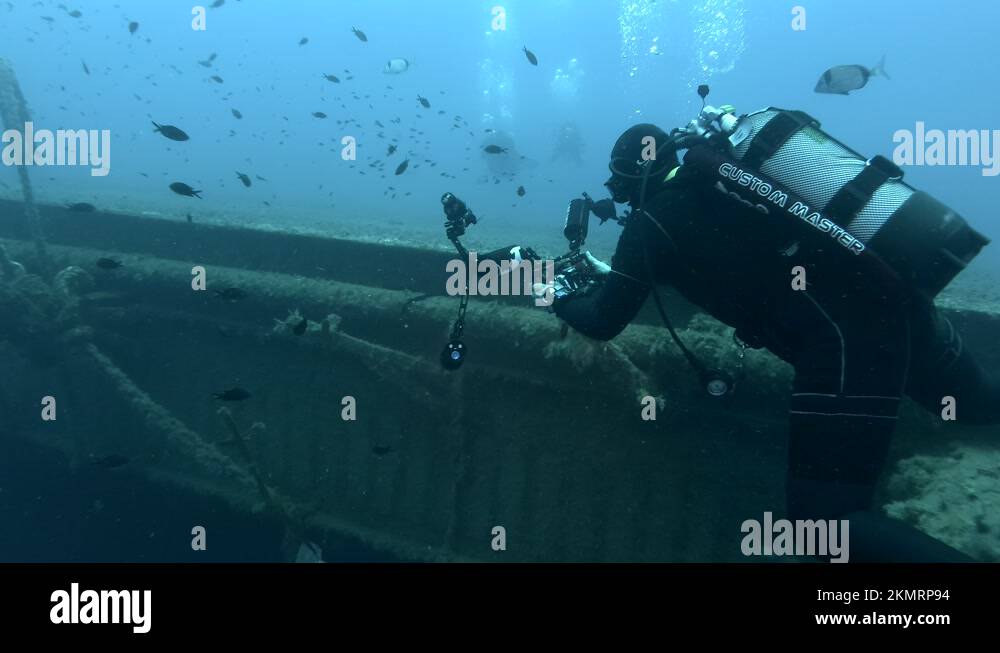 Scuba diver photographer swims on the shipwreck Swedish ferry MS ...