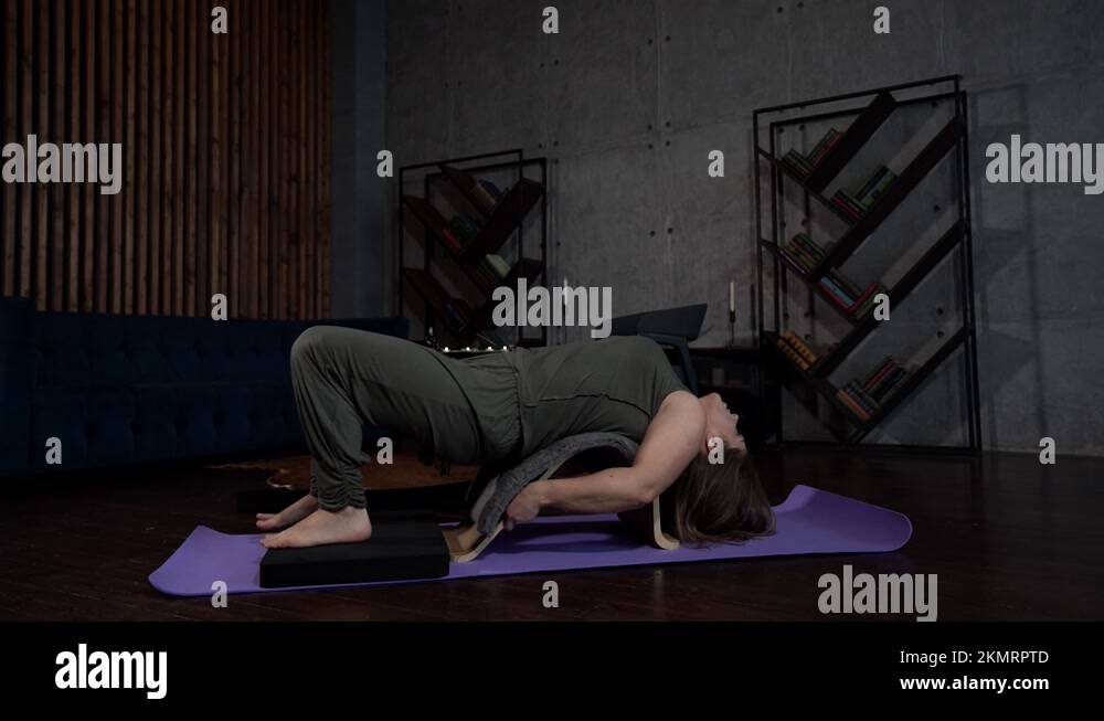 the woman has bent legs at the knees and slowly lies back on a special ...