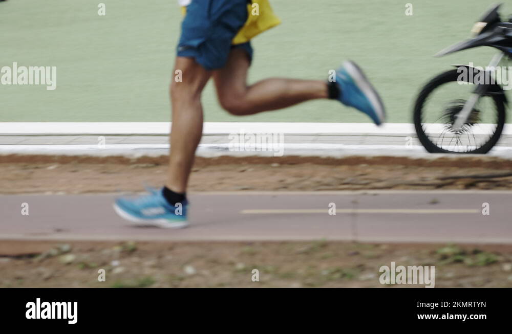 Man running exercising in a bike lane in a busy street of a big city ...
