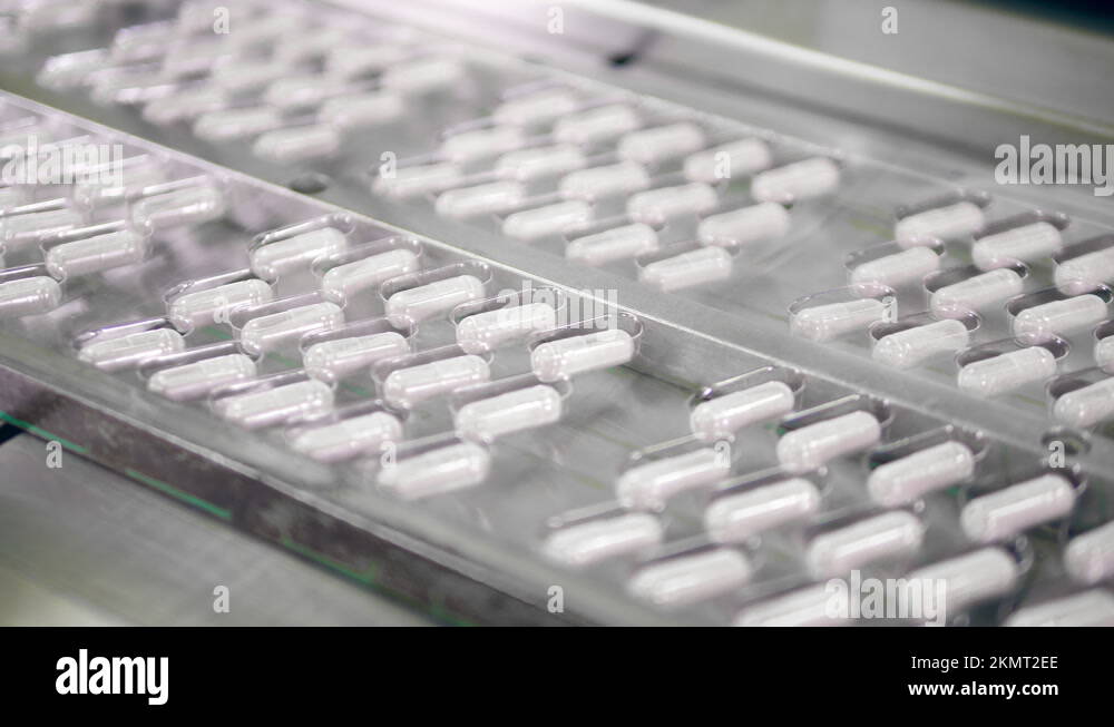 Blister packs with medication capsules moving along the conveyor. Drug ...