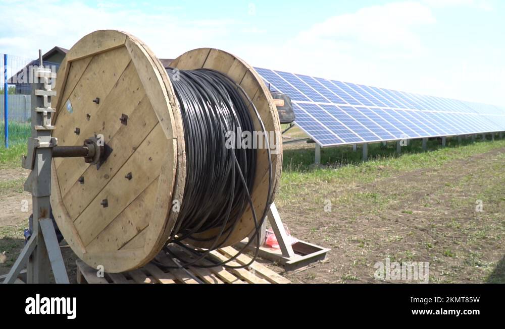 Massive roll of cable is unwinding at a construction site of solar ...