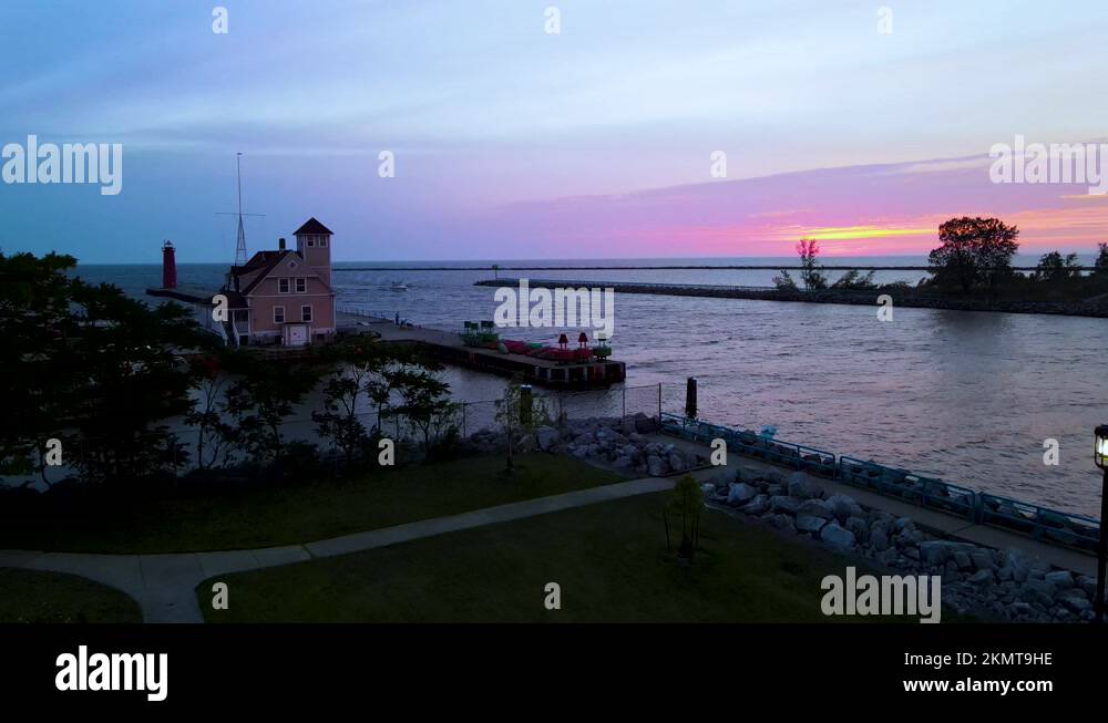 Drone lift to show the sun setting over the Lake Michigan coast line ...