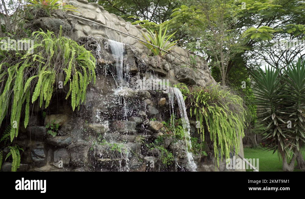 Tilting down shot of a waterfall feature in a garden in Pachacamac ...