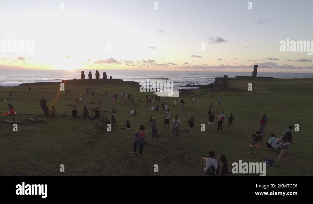 People admiring sunset with Moai in background at Ahu Tahai, Easter ...