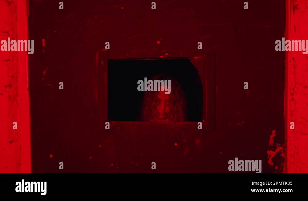 Horror acting - a woman in a straitjacket standing behind the door in ...