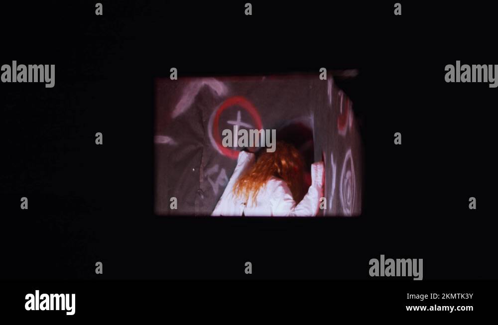 Horror acting - a woman in a straitjacket standing behind the door in ...