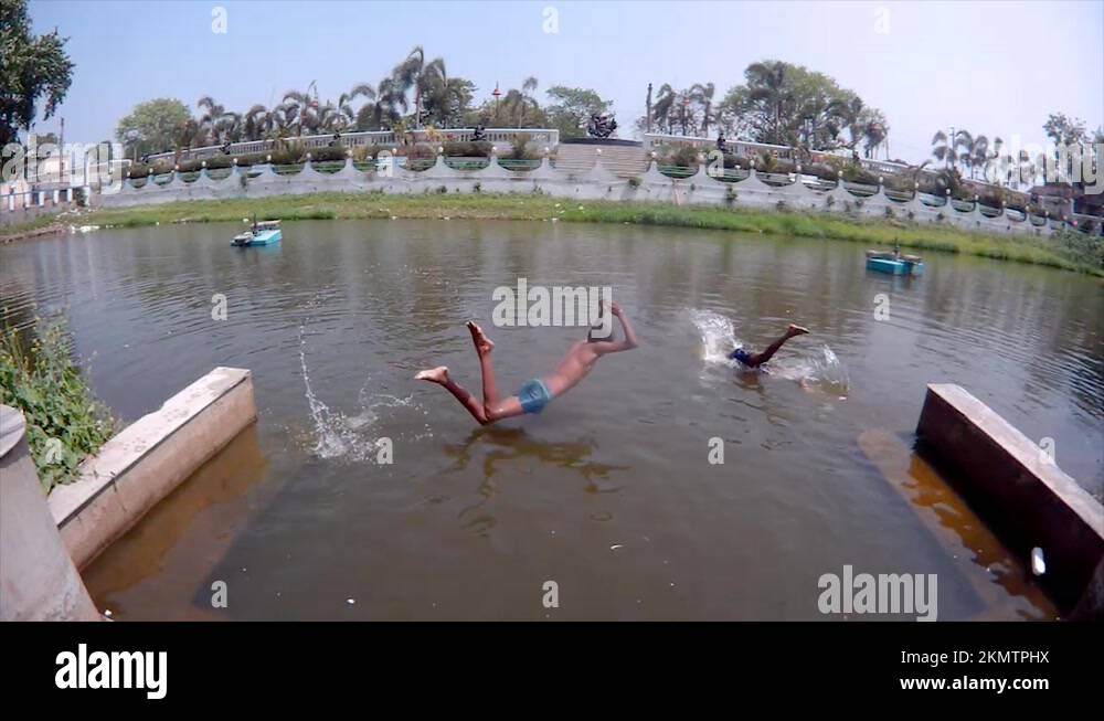 Young Asian boys jumping into pond for bathing, water splash in slow ...