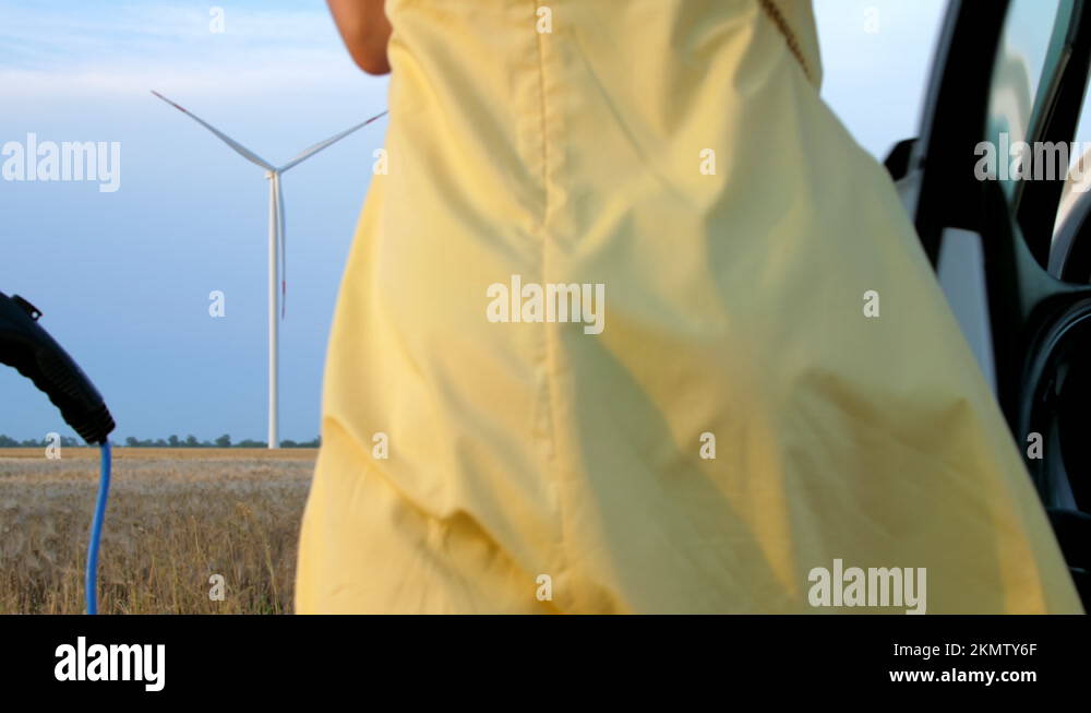 Wind turbine charges electric Tesla lady and car at station Stock Video ...