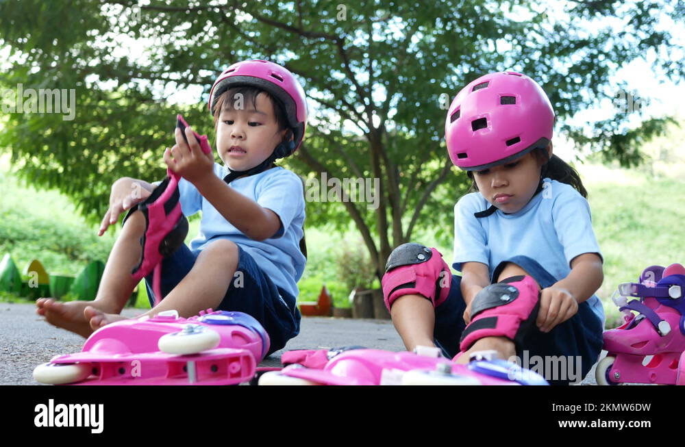Girls wearing protection pads and helmet practicing to roller skate in ...